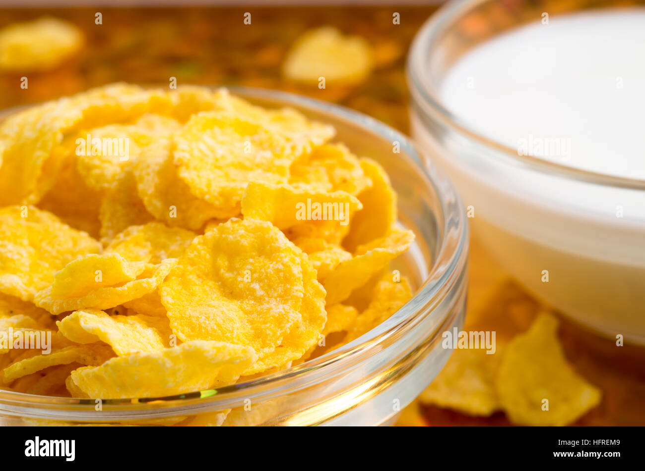 View close-up of milk and a glass bowl of cornflakes with a very small ...