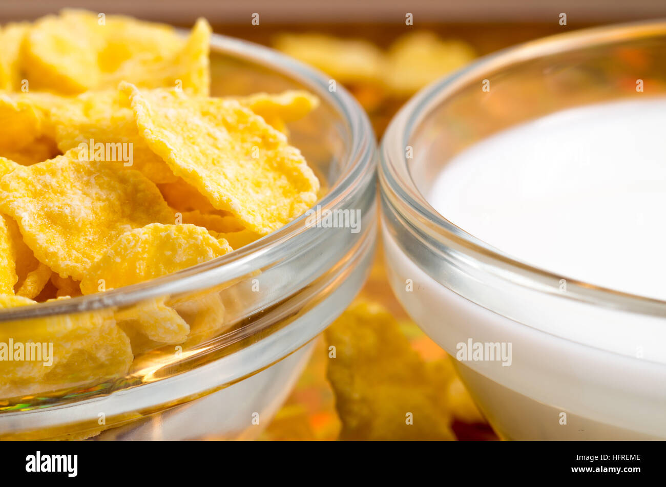 Transparent cup with milk and corn flakes close-up with very little ...