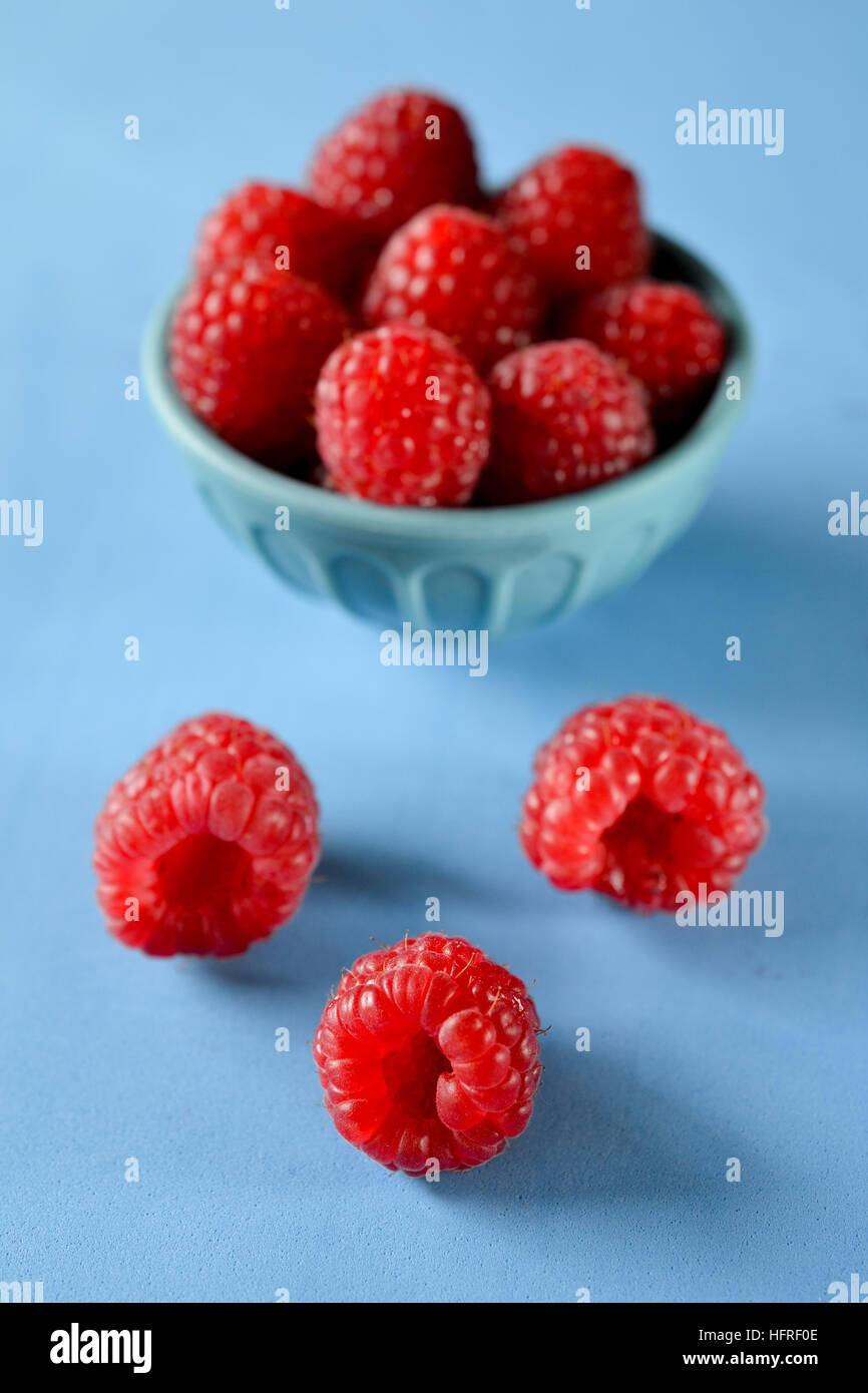 Abstract red and blue composition showing intense red raspberries in ...