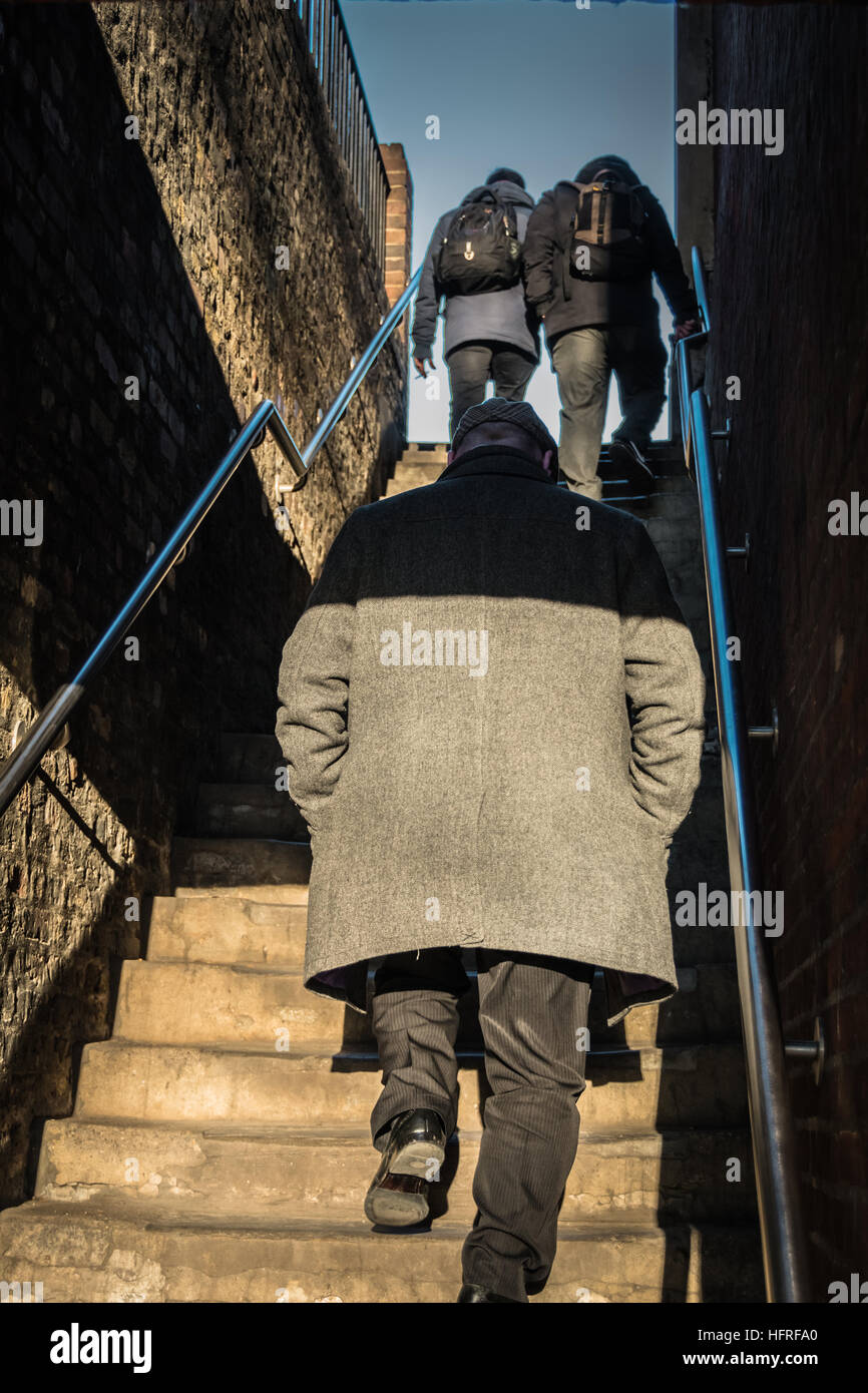 An old man climbing up stone stairs in London Stock Photo - Alamy