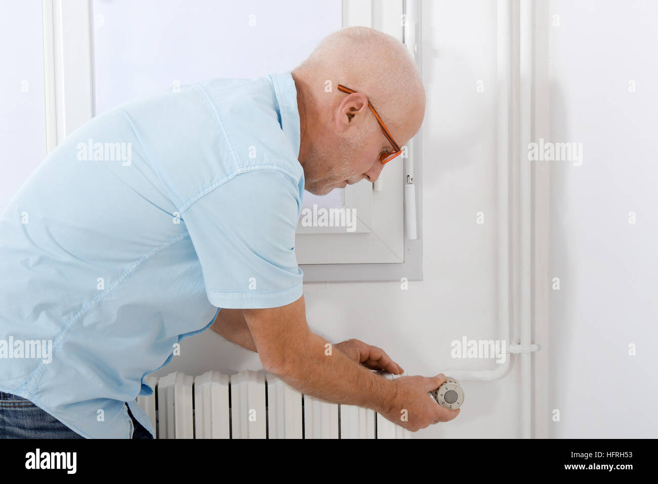 handsome mature man changing temperature of radiator Stock Photo - Alamy