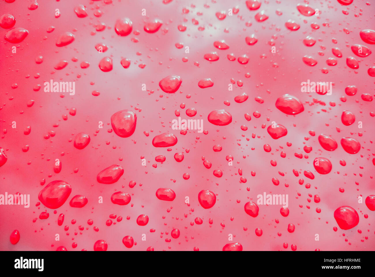 Rain drops on red background as background Stock Photo - Alamy