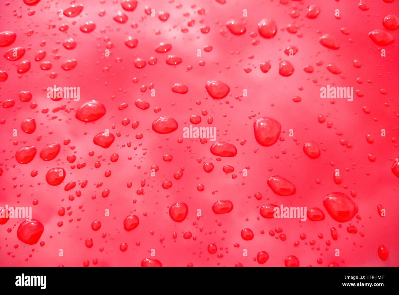 Rain drops on red background as background Stock Photo - Alamy