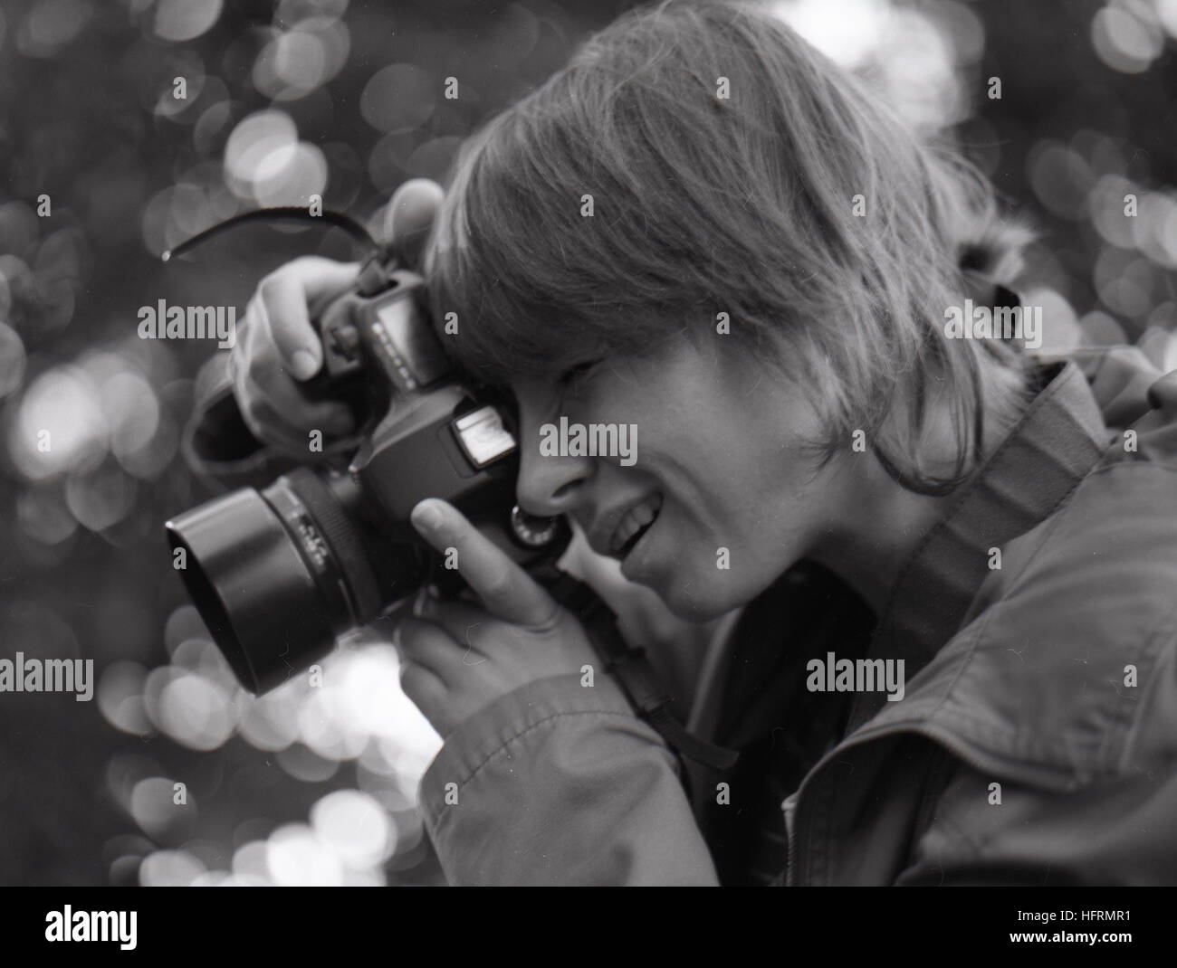 Black-and-white photo of a girl who takes on the camera. Granular and ...