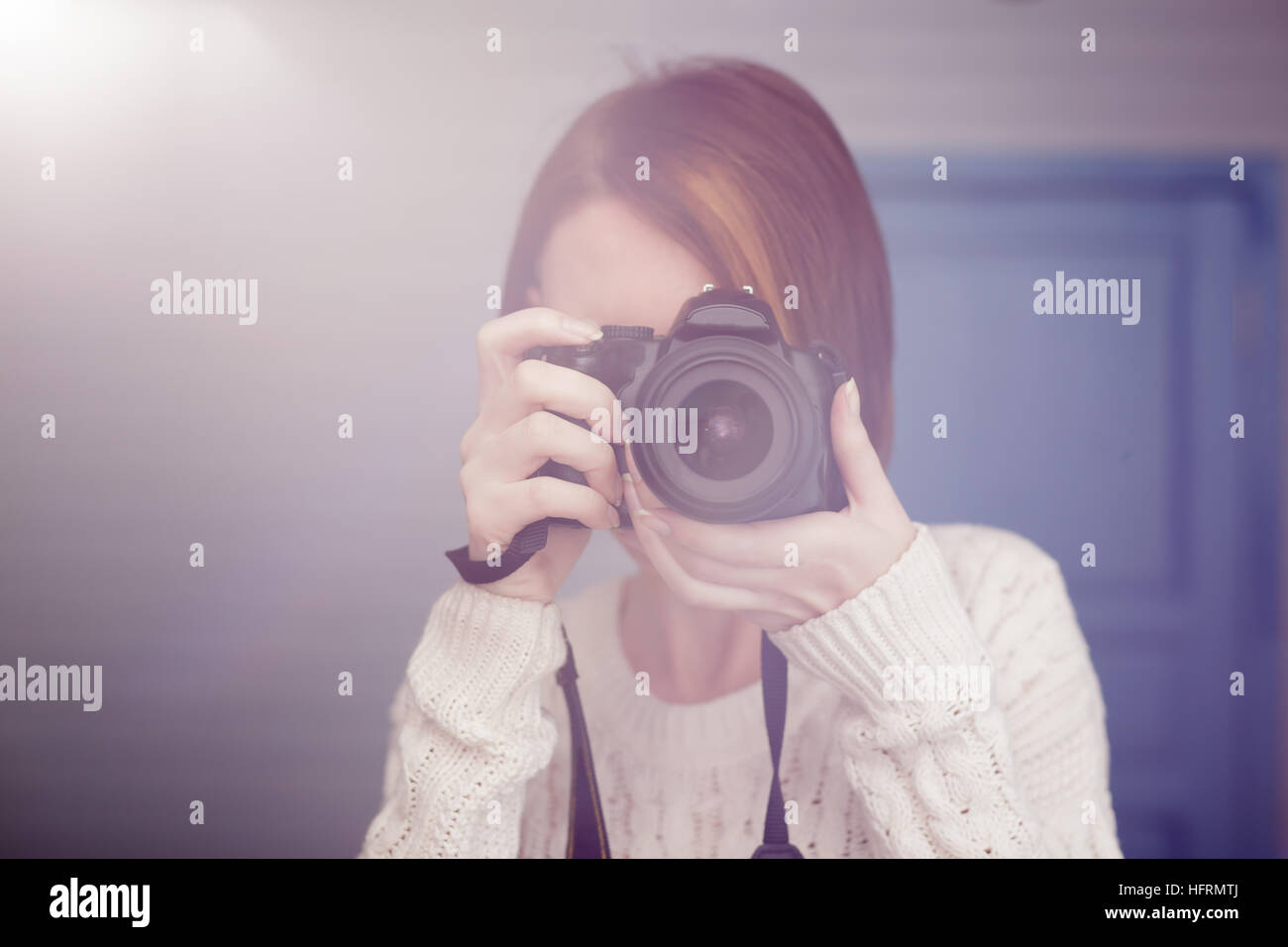 girl holds a digital camera and looks in the optical viewfinder by ...
