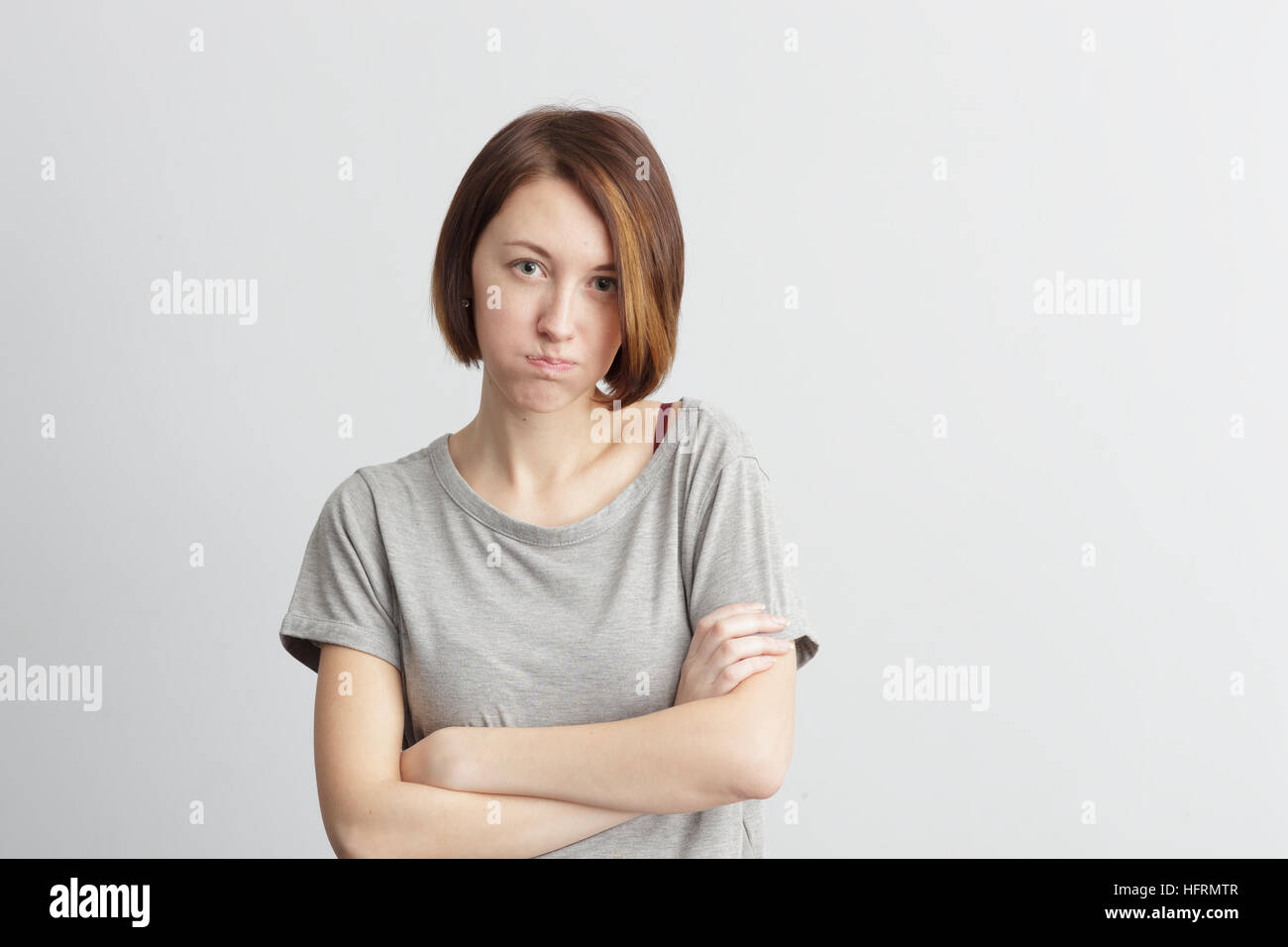 Girl puffed out her cheeks. She is offended and dissatisfied. Hands ...