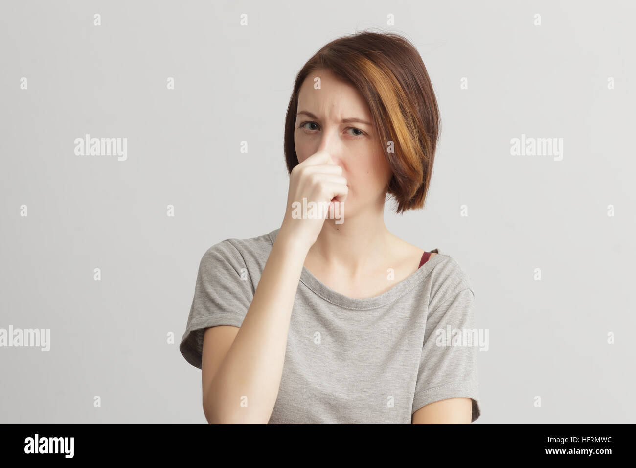 Disgusting smelling. Girl frowns with displeasure Stock Photo - Alamy