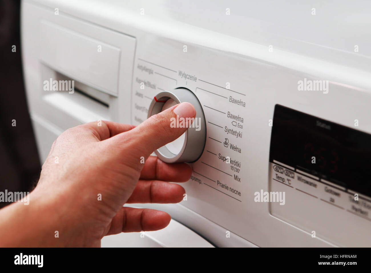 Close up of man's hand adjusting washing machine Stock Photo - Alamy