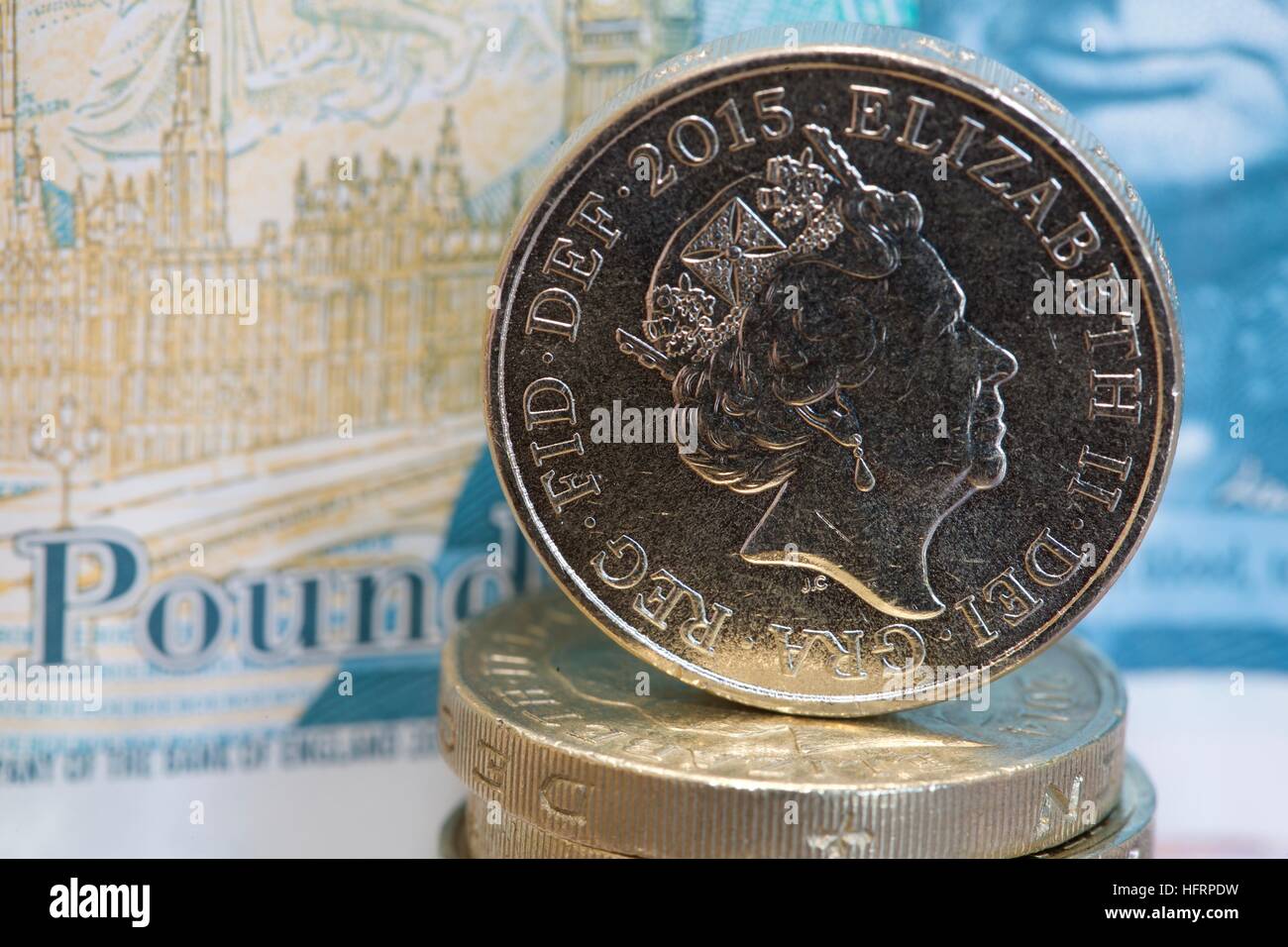 Close-up of a one pound coin with a new five pound note in the back ...