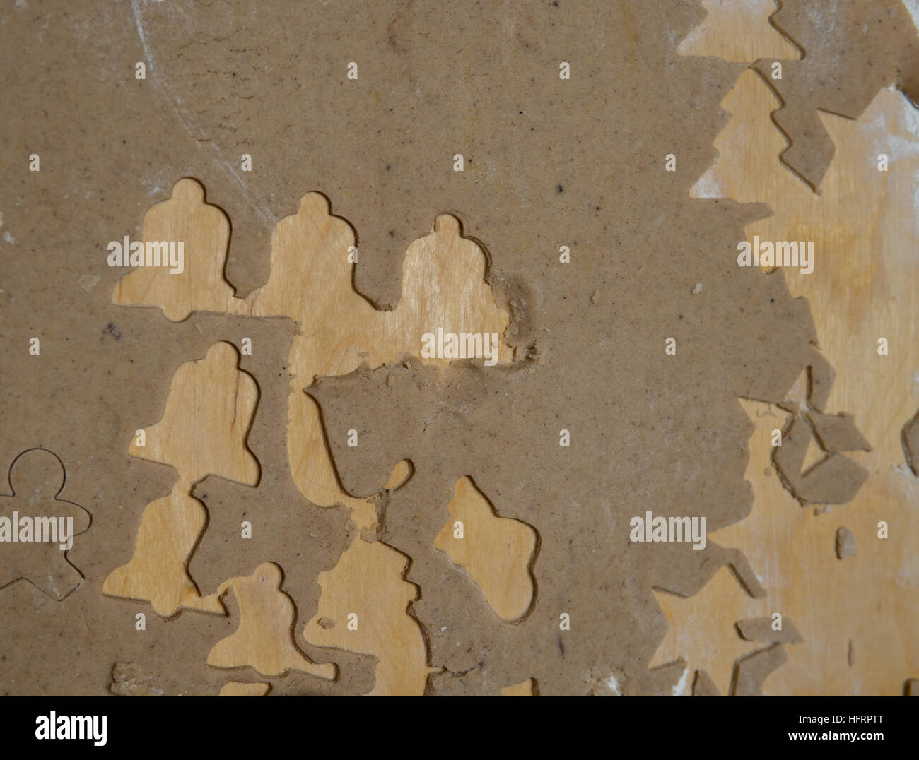 shape of a bell cutted out from a layer of gingerbread dough on a ...