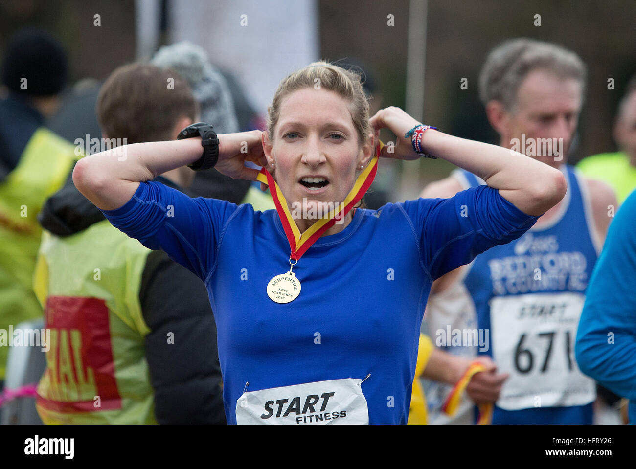 A runner places her medal around her neck after taking part in the ...