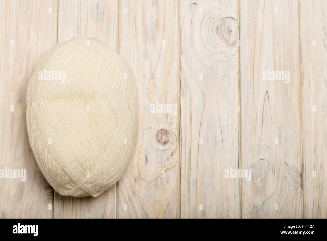 White yarn on light wood background Stock Photo - Alamy