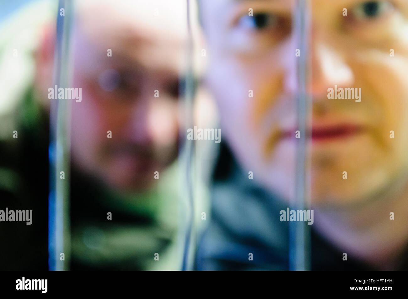 Two men look through bars of a cage (deliberately defocussed Stock ...