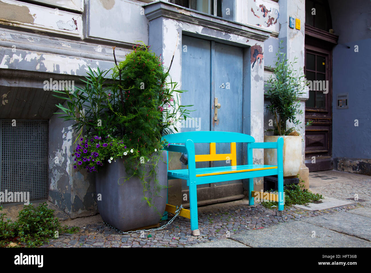 A blue bench in front of a typical entrance of an old building in ...