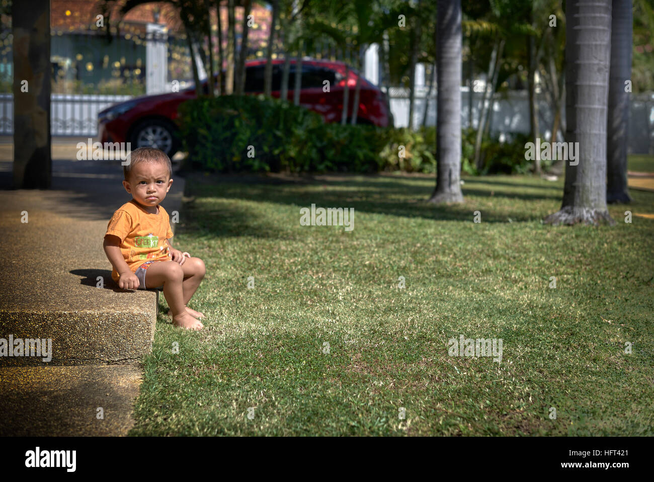 Child alone outside in the garden Stock Photo - Alamy