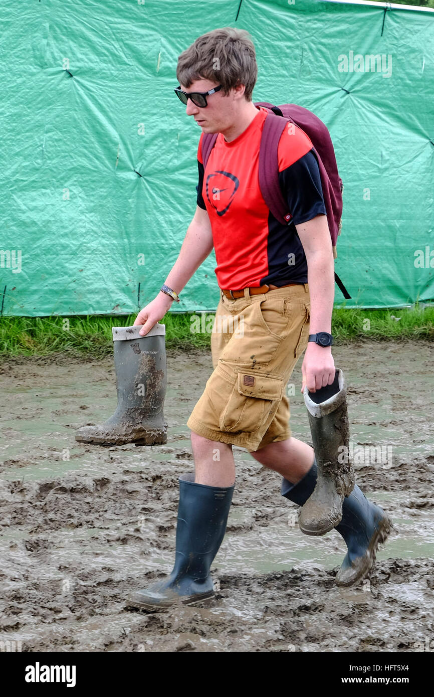 Festival Goers walk through the mud at during the Glastonbury 2016 ...