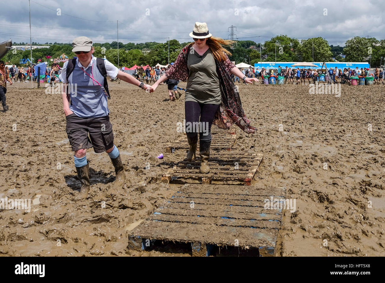 Festival Goers walk through the mud at during the Glastonbury 2016 ...