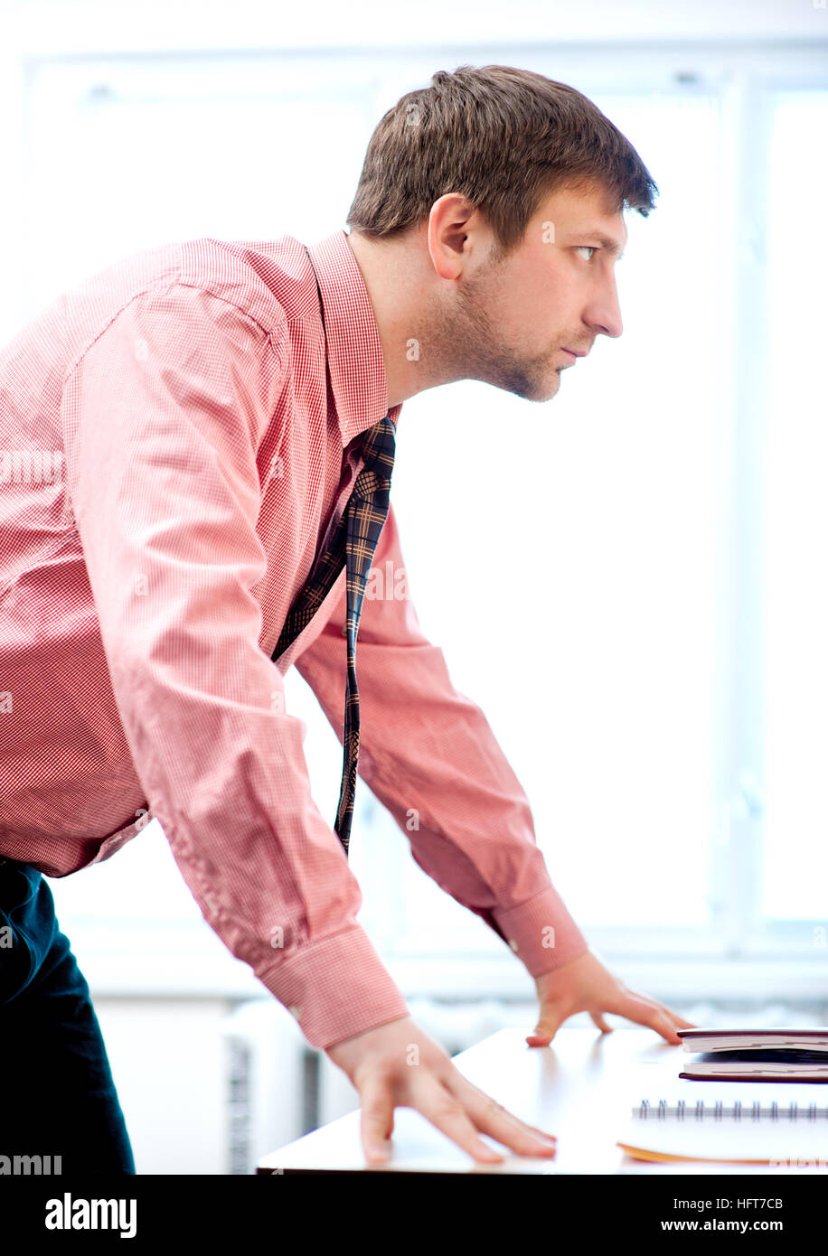 Angry businessman leans on the table Stock Photo - Alamy