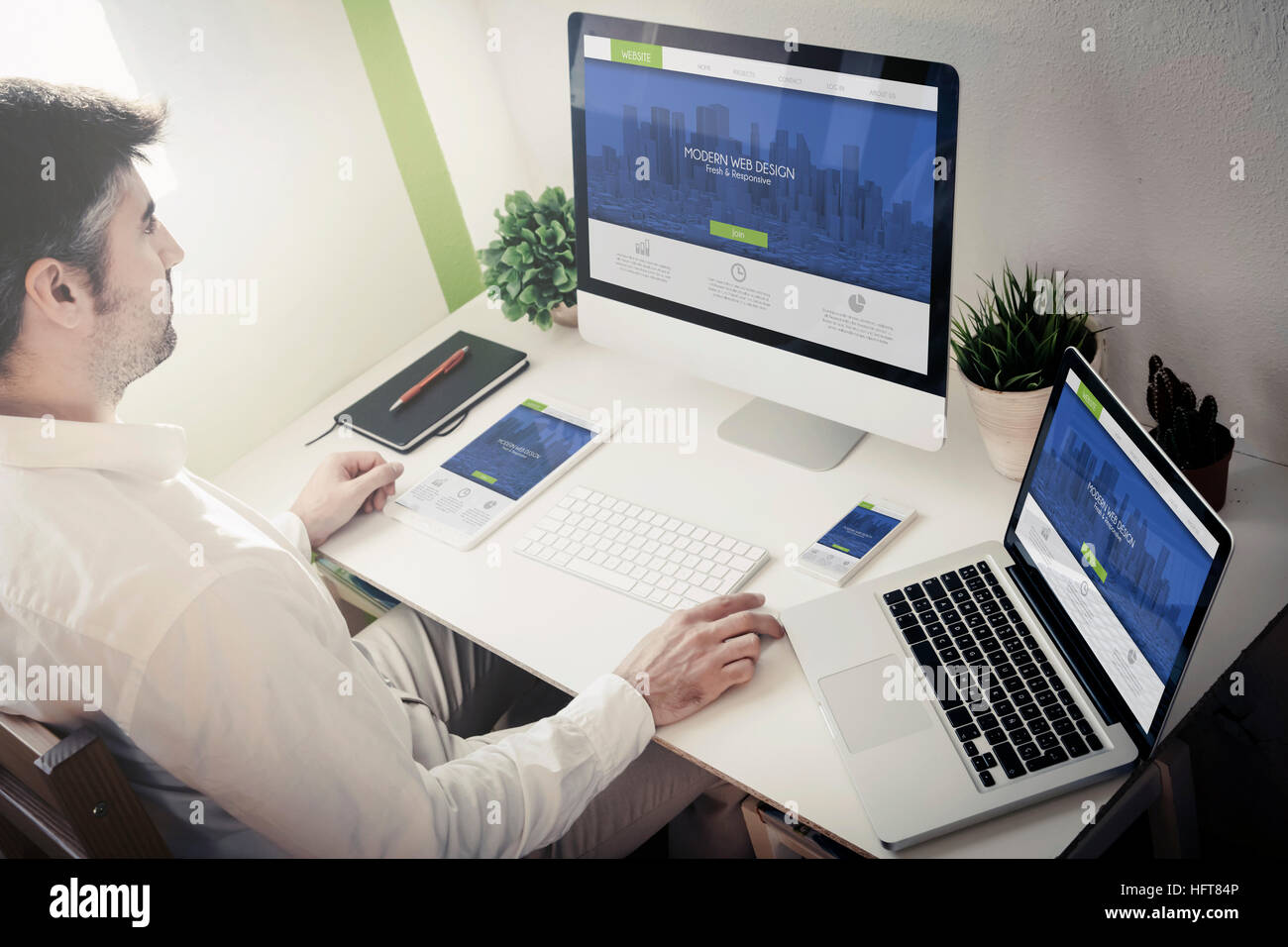 man working with devices with responsive web design. All screen graphics are made up Stock Photo ...