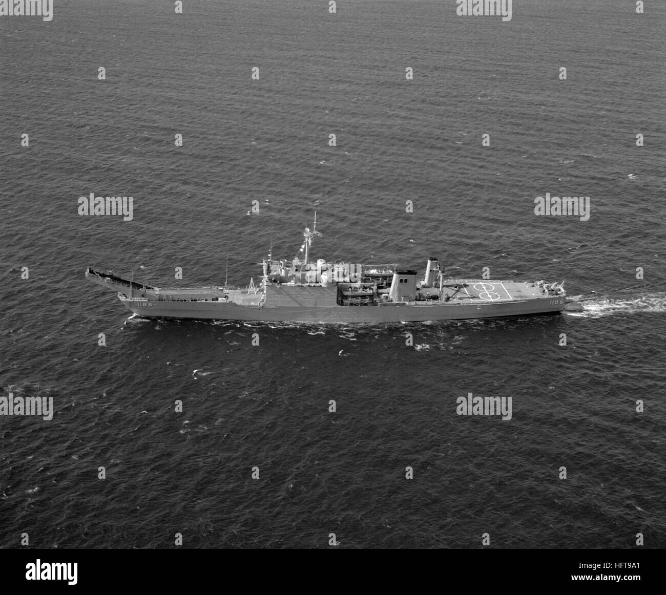 An elevated port-side view shows the tank landing ship USS Cayuga ...