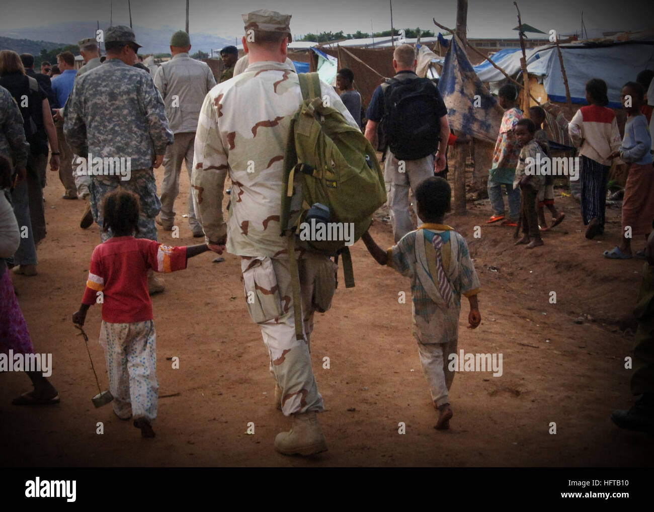 U.S. Navy Lt. Cmdr. Jeff Weitz walks holding hands with two children ...