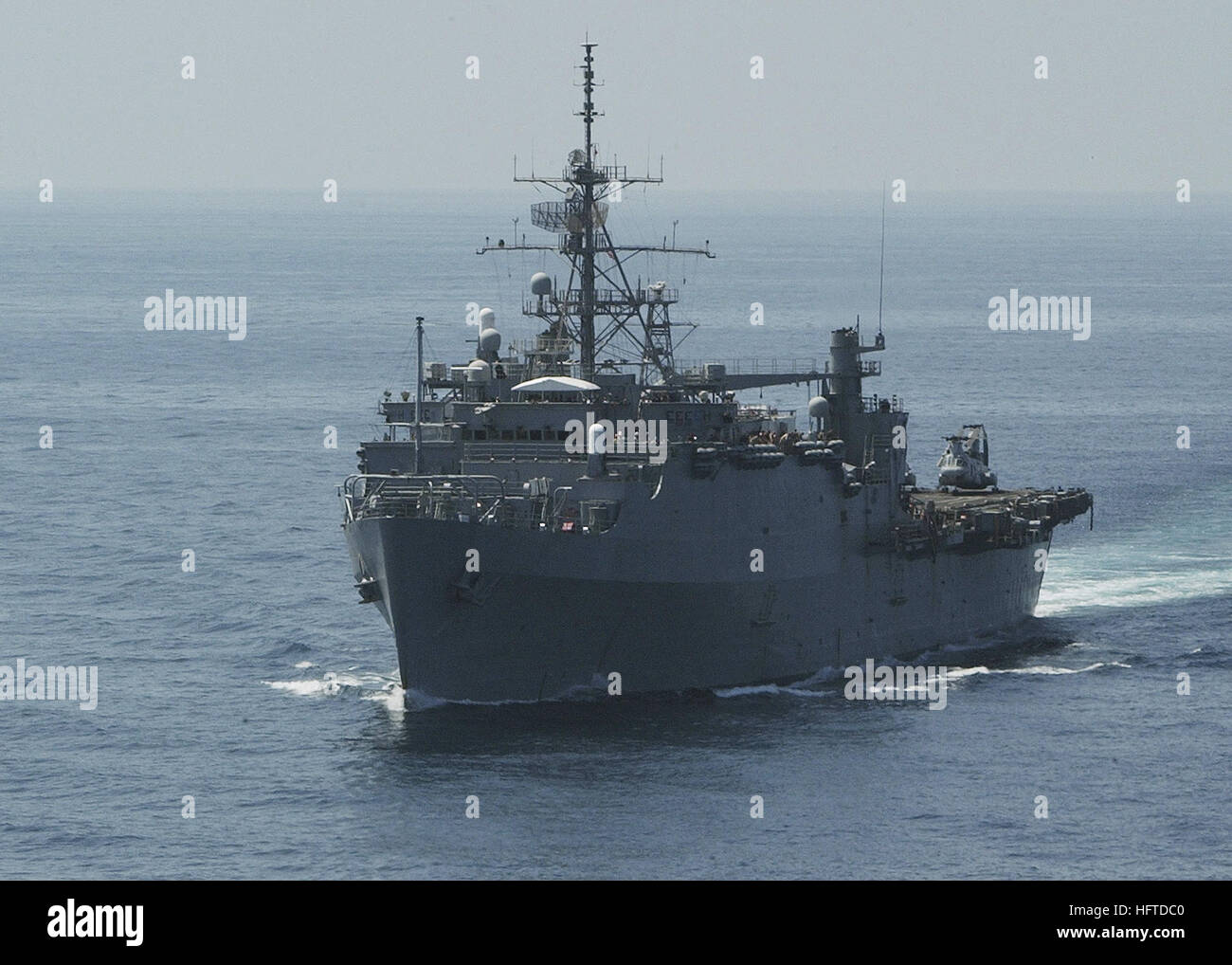 An Amphibious Transport Doch ship, USS Austin (LPD 4), sails behind the ...