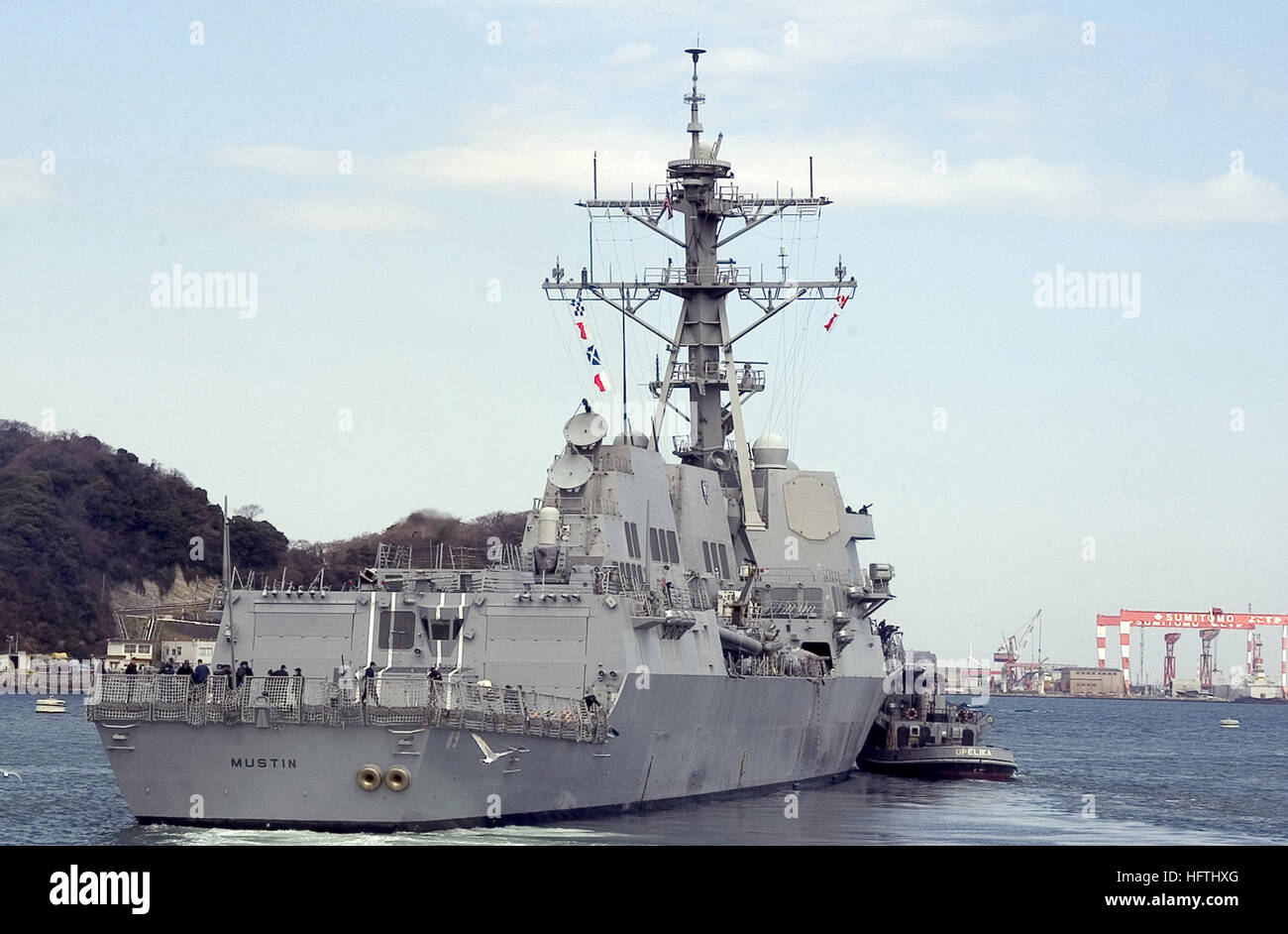 The large harbor tug USS Opelika (YTB 798) helps guide the Arleigh ...