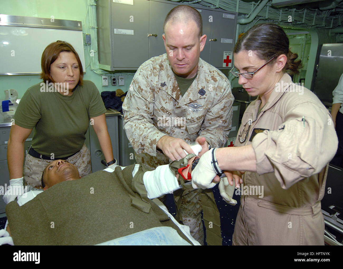 Hospital Corpsmen perform an arm splint during a chemical, biological ...