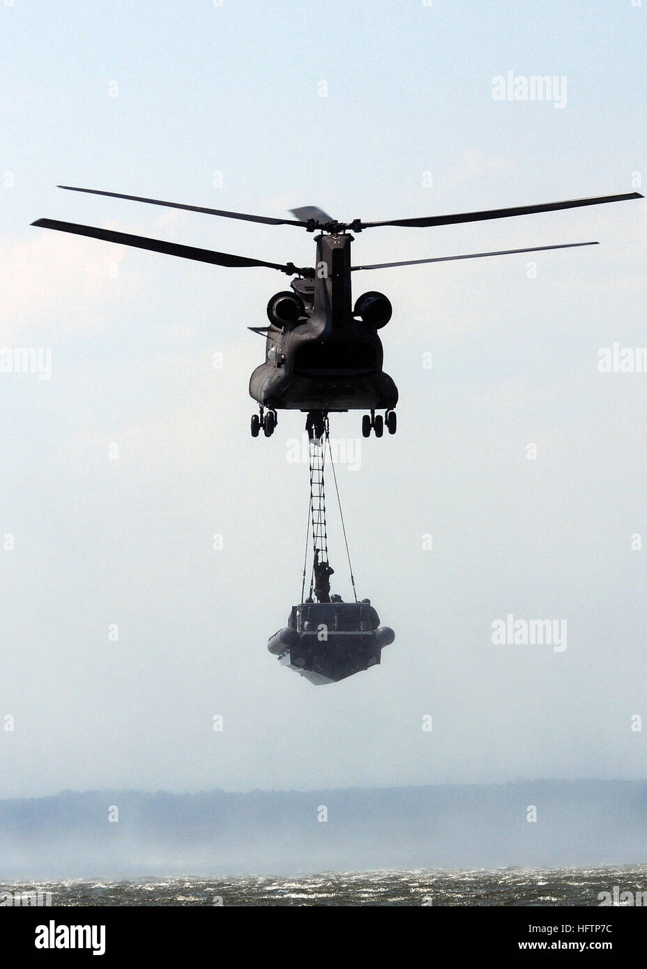 Helicopter lifts a rigid hull inflatable boat hi-res stock photography ...