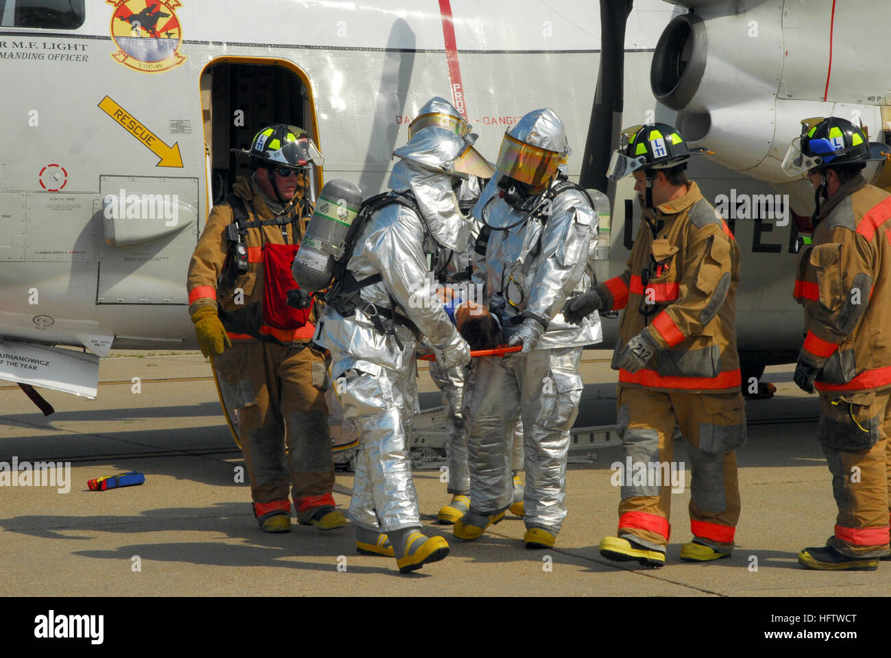 Firemen from the Navy Mid-Atlantic Region Fire and Rescue Team assist ...