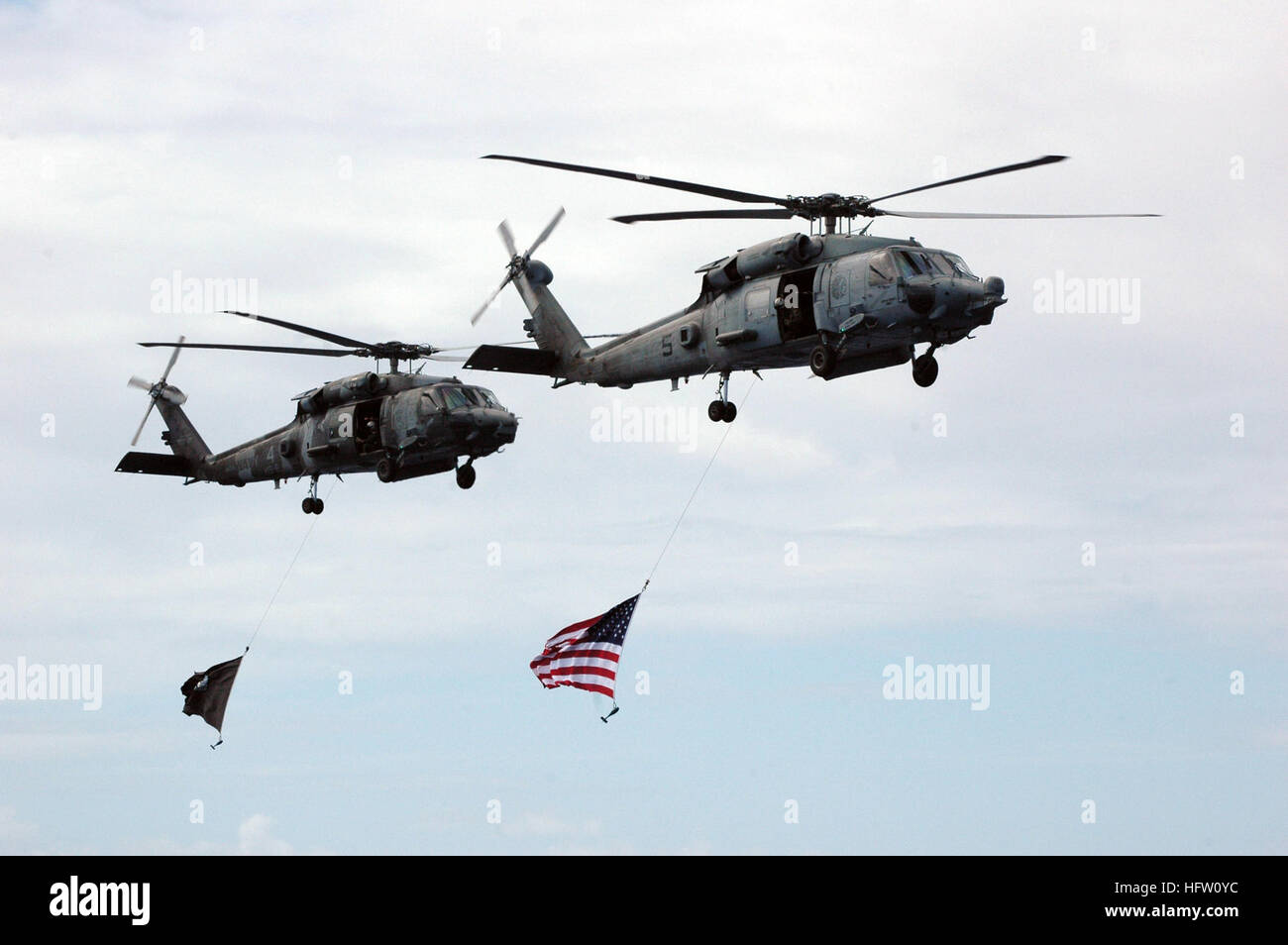 Two SH-60F Seahawks from HS-6 fly American and POW/MIA flags over USS ...