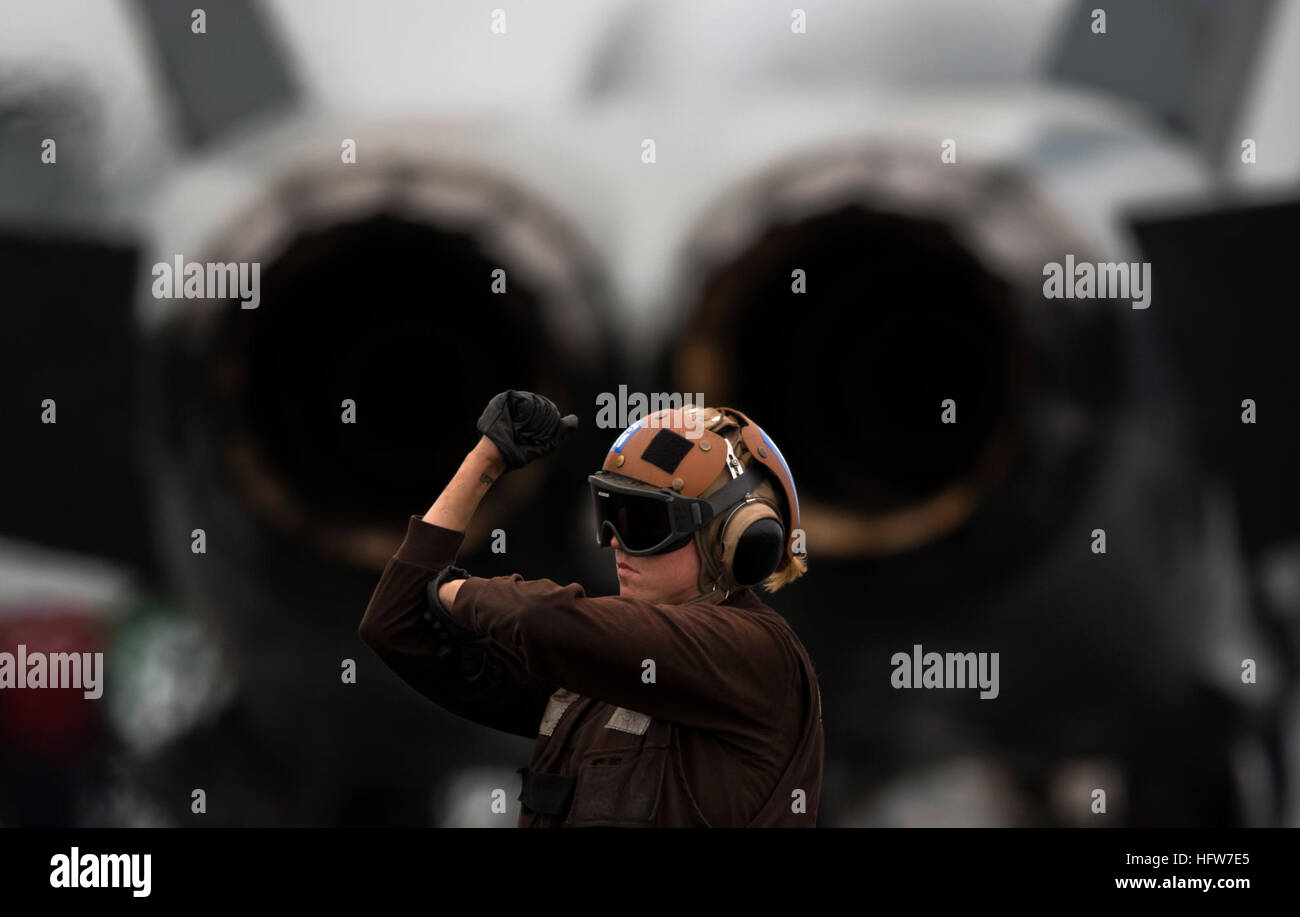 A plane captain aboard USS Abraham Lincoln (CVN 72) directs a pilot ...