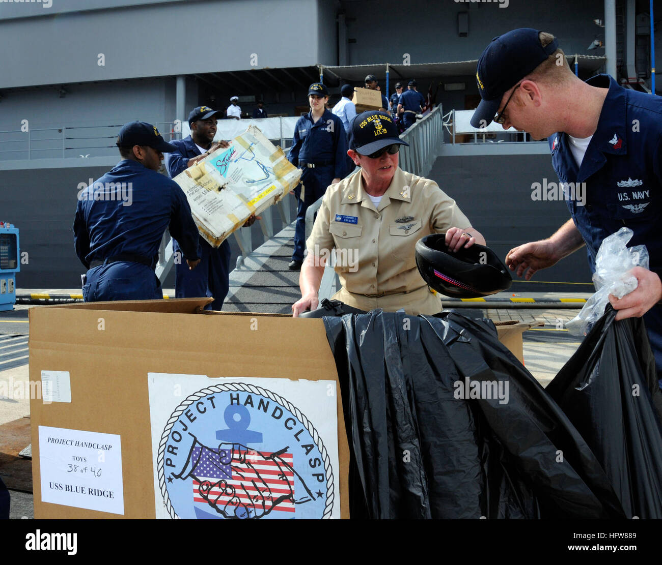 Sailors aboard the amphibious command ship USS Blue Ridge unload ...