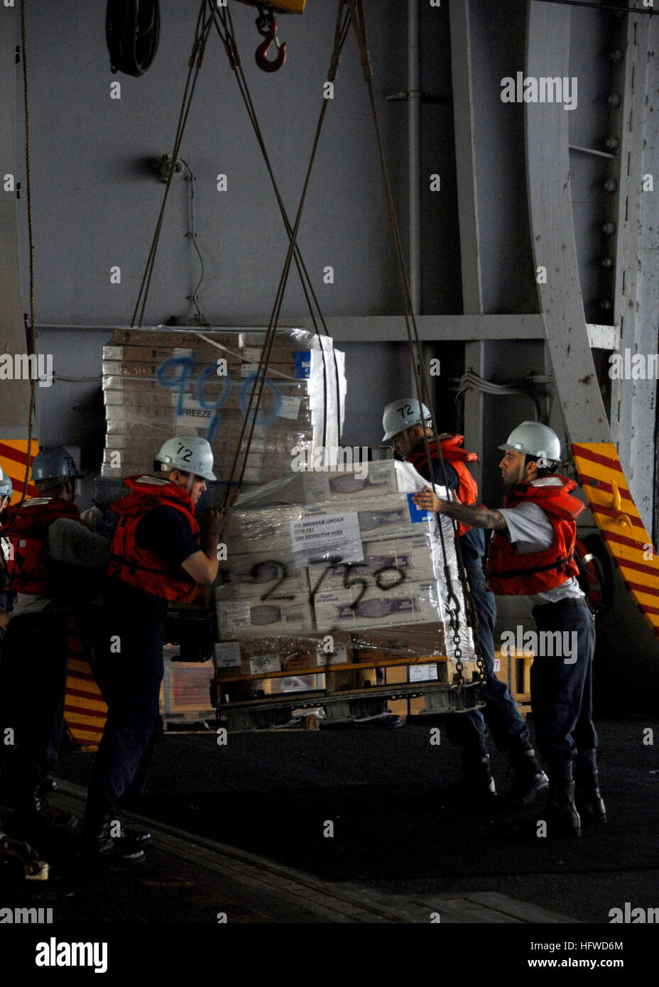 Sailors use a crane and pulley system to transfer supplies from USNS ...