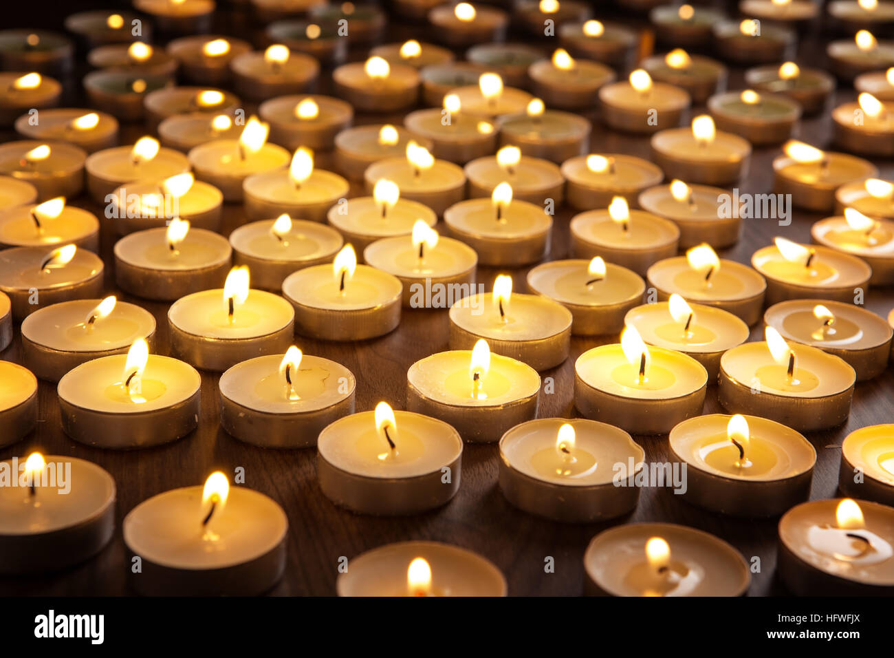 many tea candles lit on table Stock Photo - Alamy