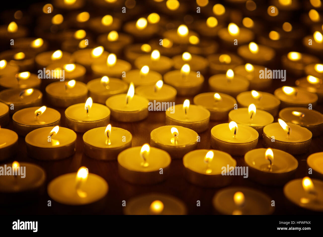 many tea candles lit on table Stock Photo - Alamy