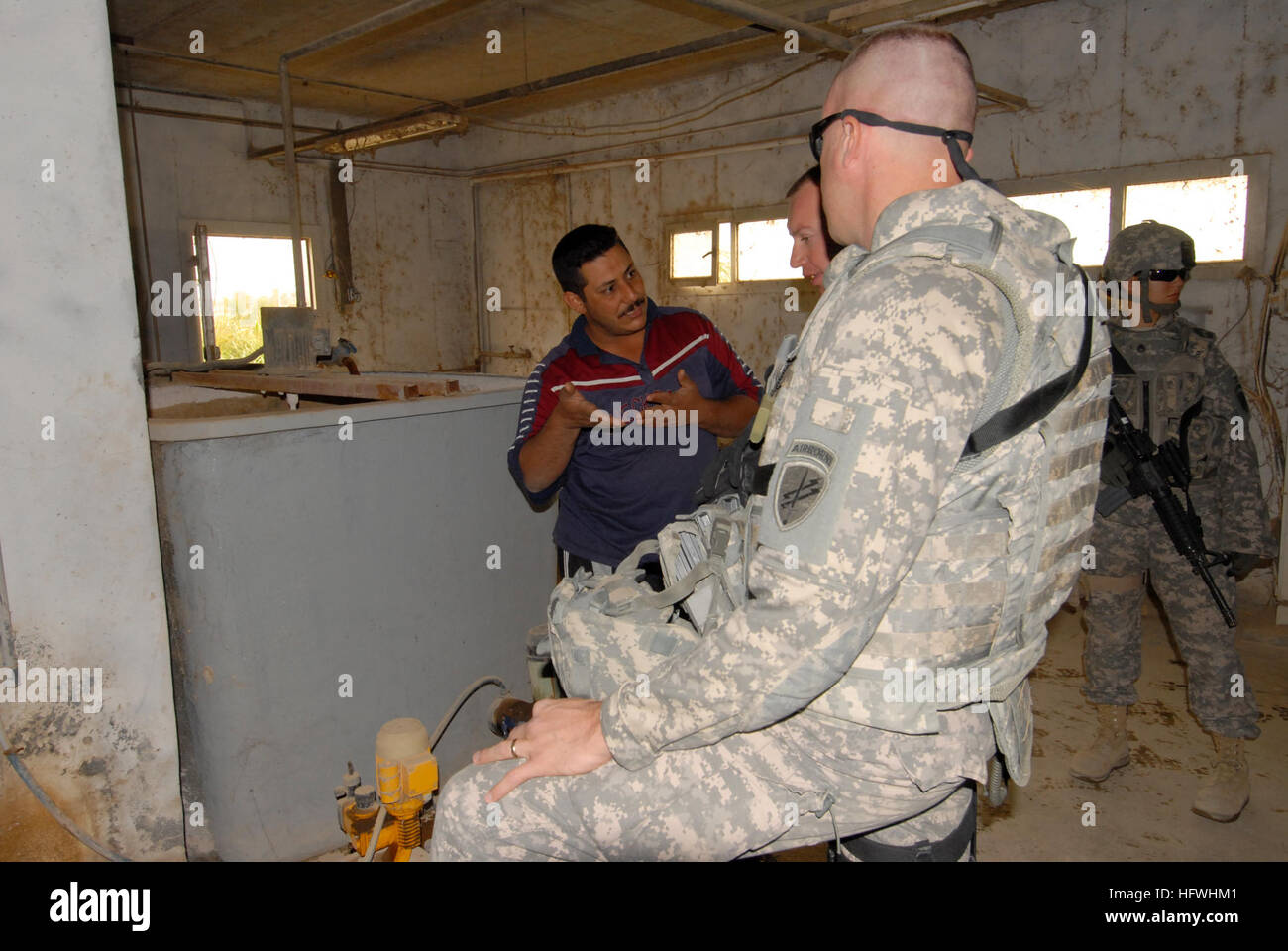 An Iraqi water treatment plant worker talks to U.S. Army Capt. William ...