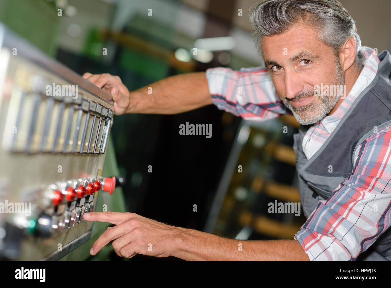 Portrait of man pressing button on machine Stock Photo - Alamy