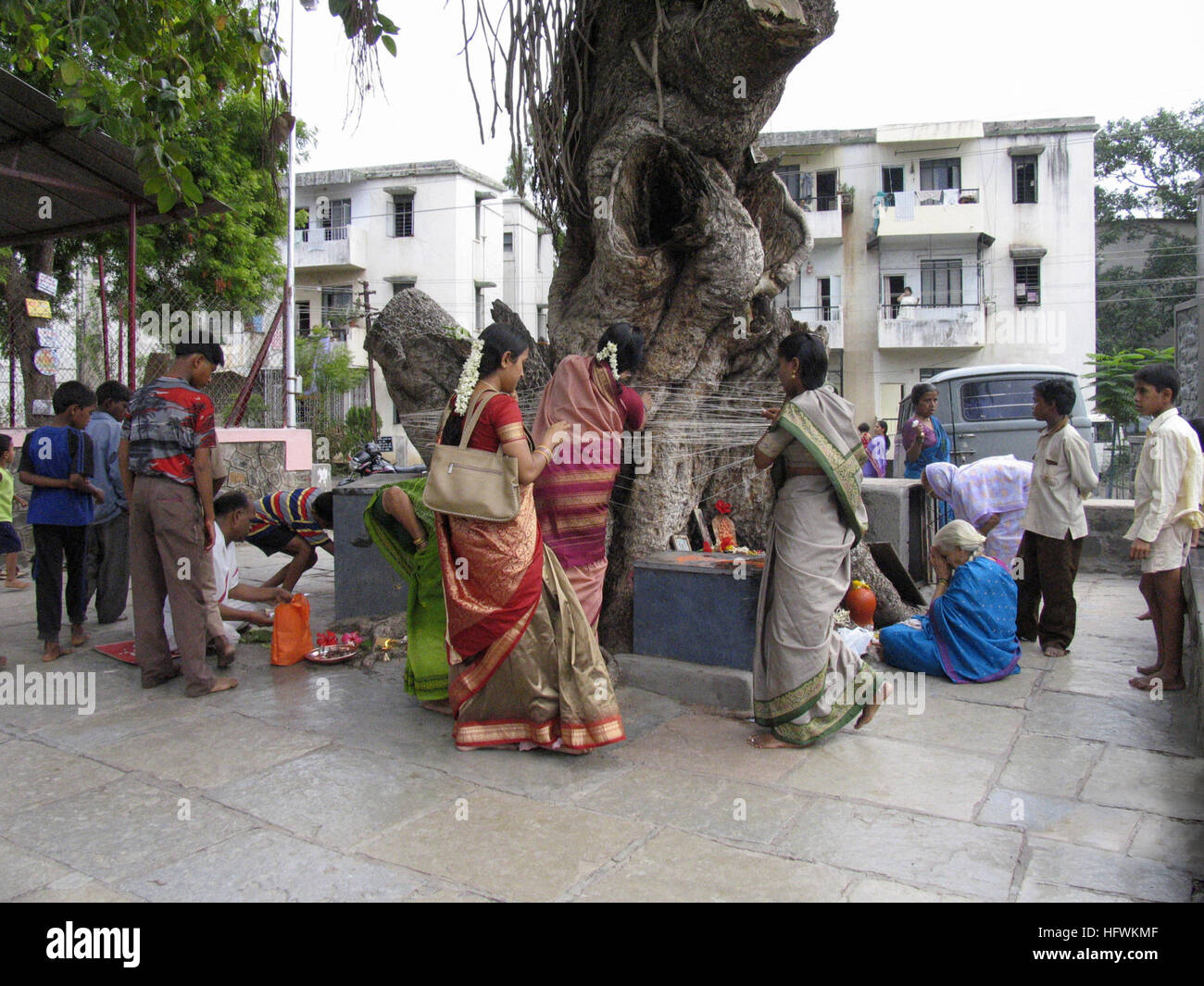 Indian Festival - Vat Savitri: woman tying thread around banyan tree ...