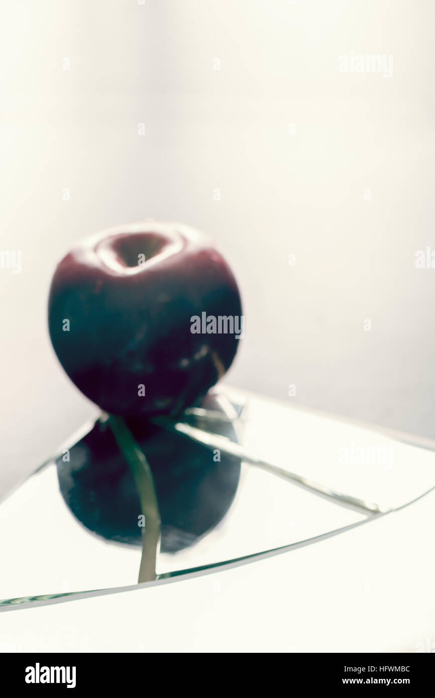 Defocused red apple on cracked broken mirror reflecting Stock Photo - Alamy