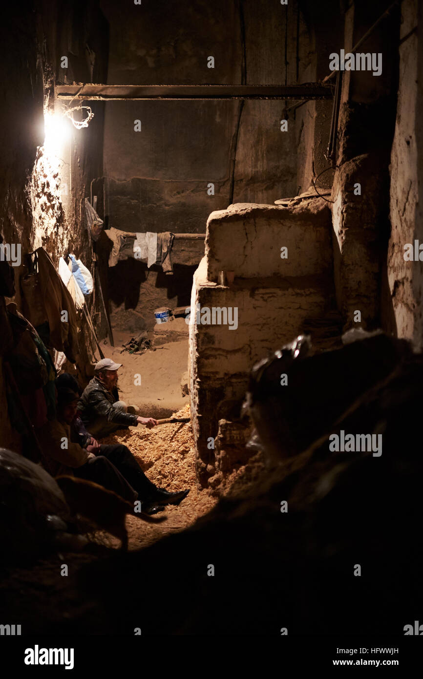 A man puts sawdust into the furnace of a hammam, a Turkish steam room ...
