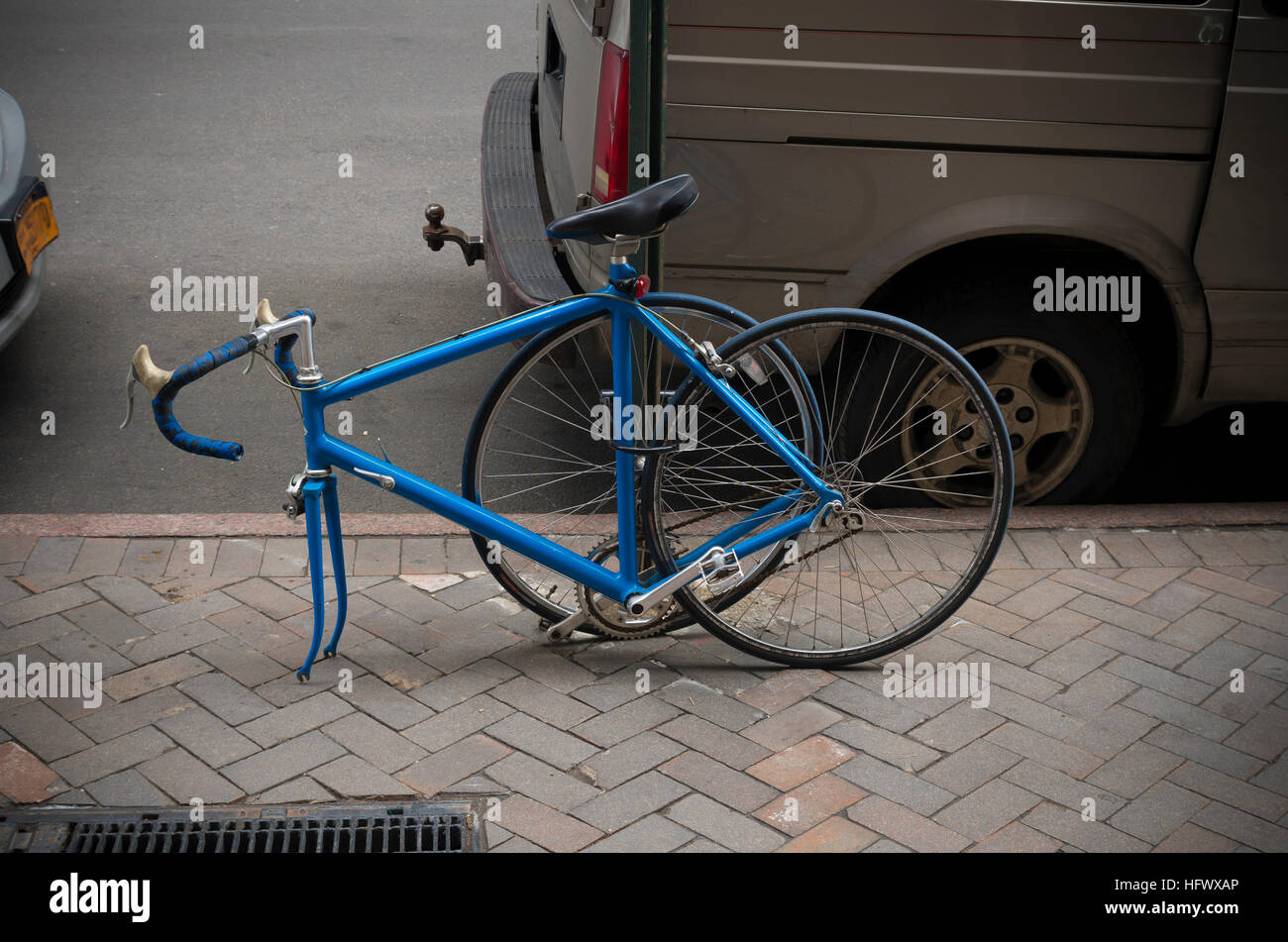locked blue racing bike with dismounted front wheel to prevent theft ...