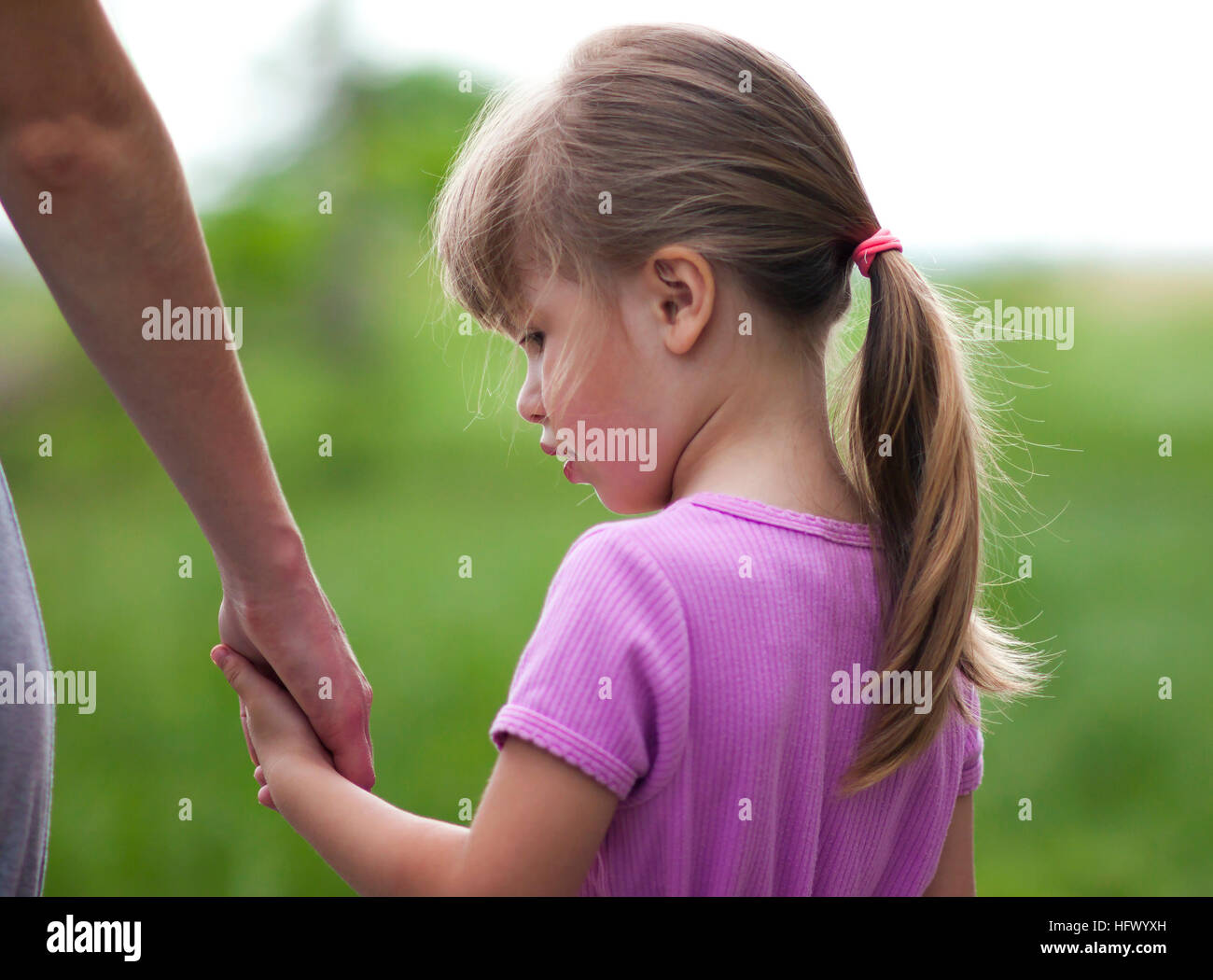 Little girl holding a hand of her mother. Family relations concept ...