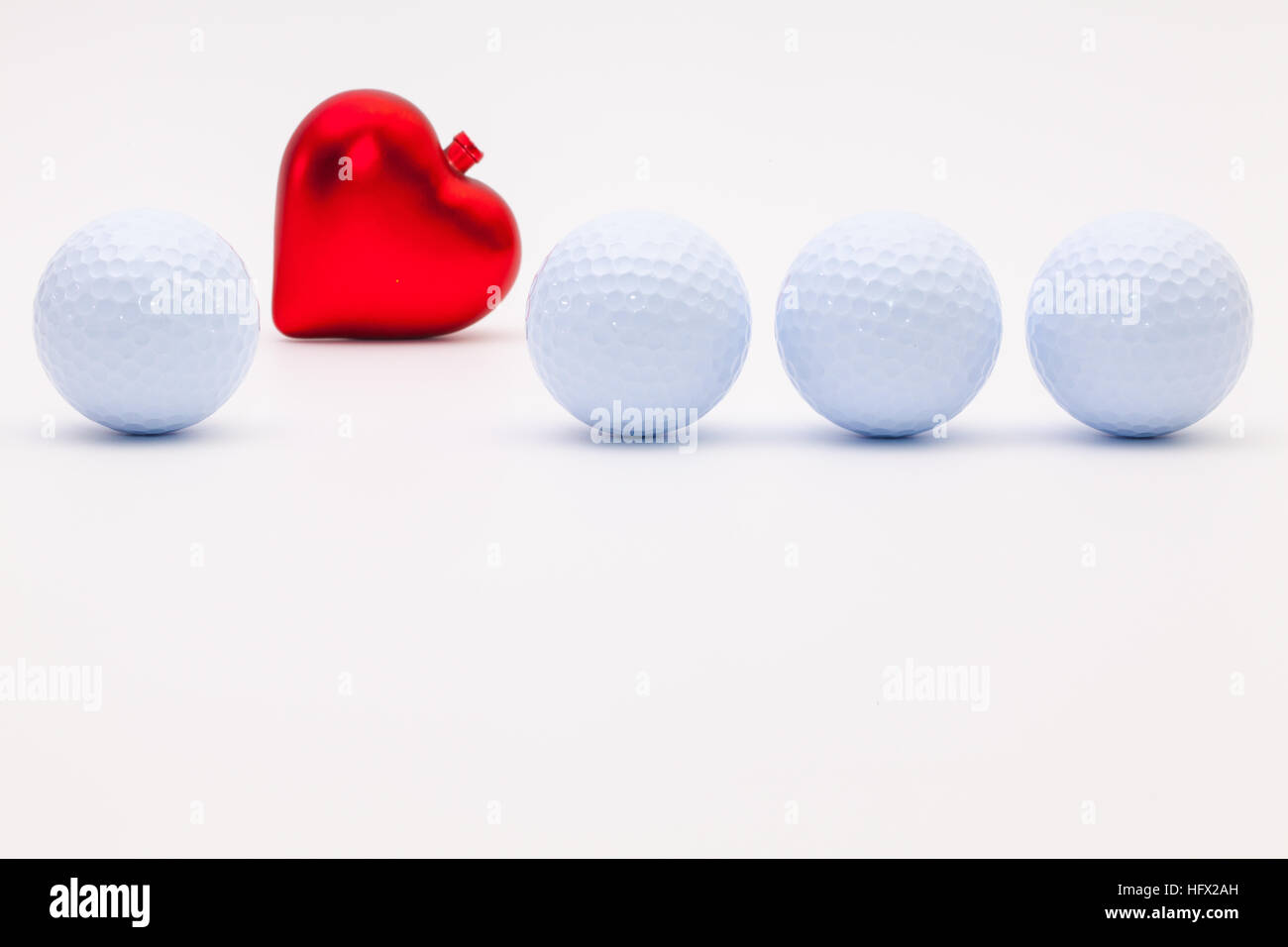 White golf balls and red heart on the white background Stock Photo - Alamy