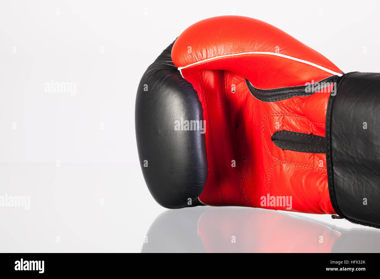 Red and black boxing gloves on a glass table isolated on white ...
