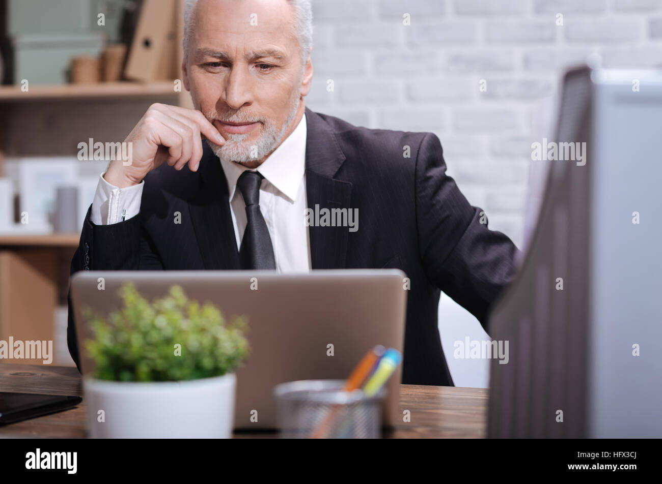 Curious gentleman watching something on his computer Stock Photo - Alamy