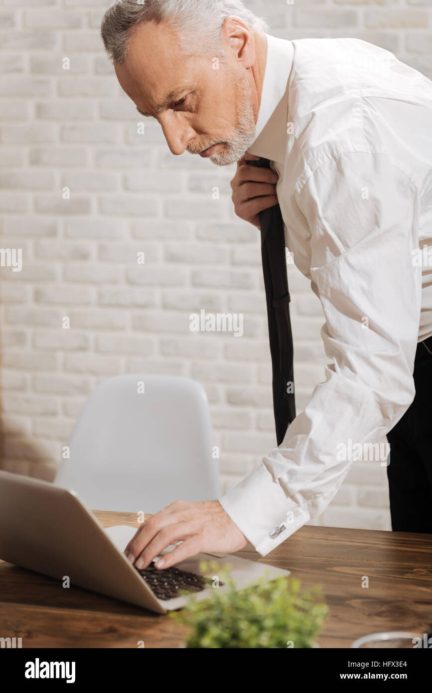 Nervous executive looking at the screen of his laptop Stock Photo - Alamy