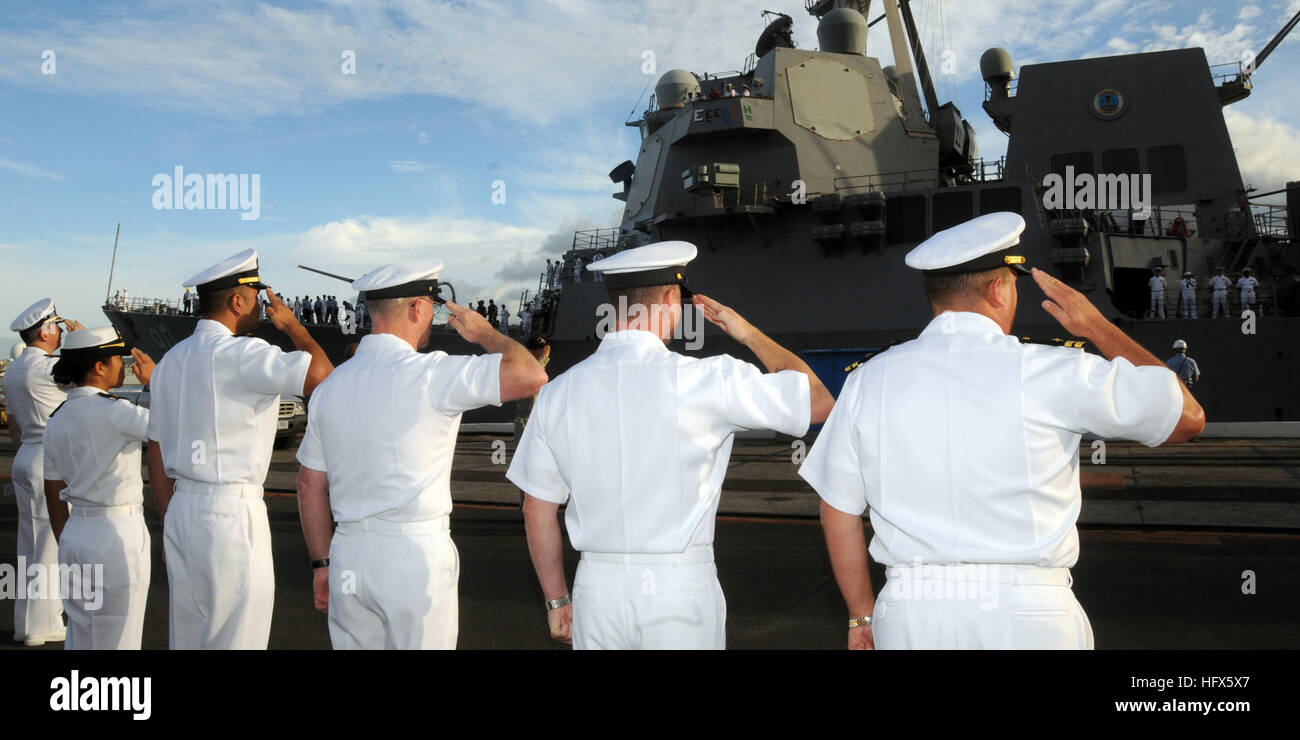 Officers and chief petty officers salute during morning colors as USS ...