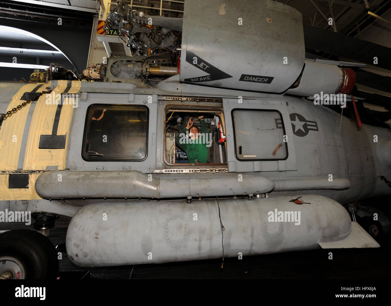 Petty Officer 2nd Class Todd Weyh conducts a spring alignment on the ...