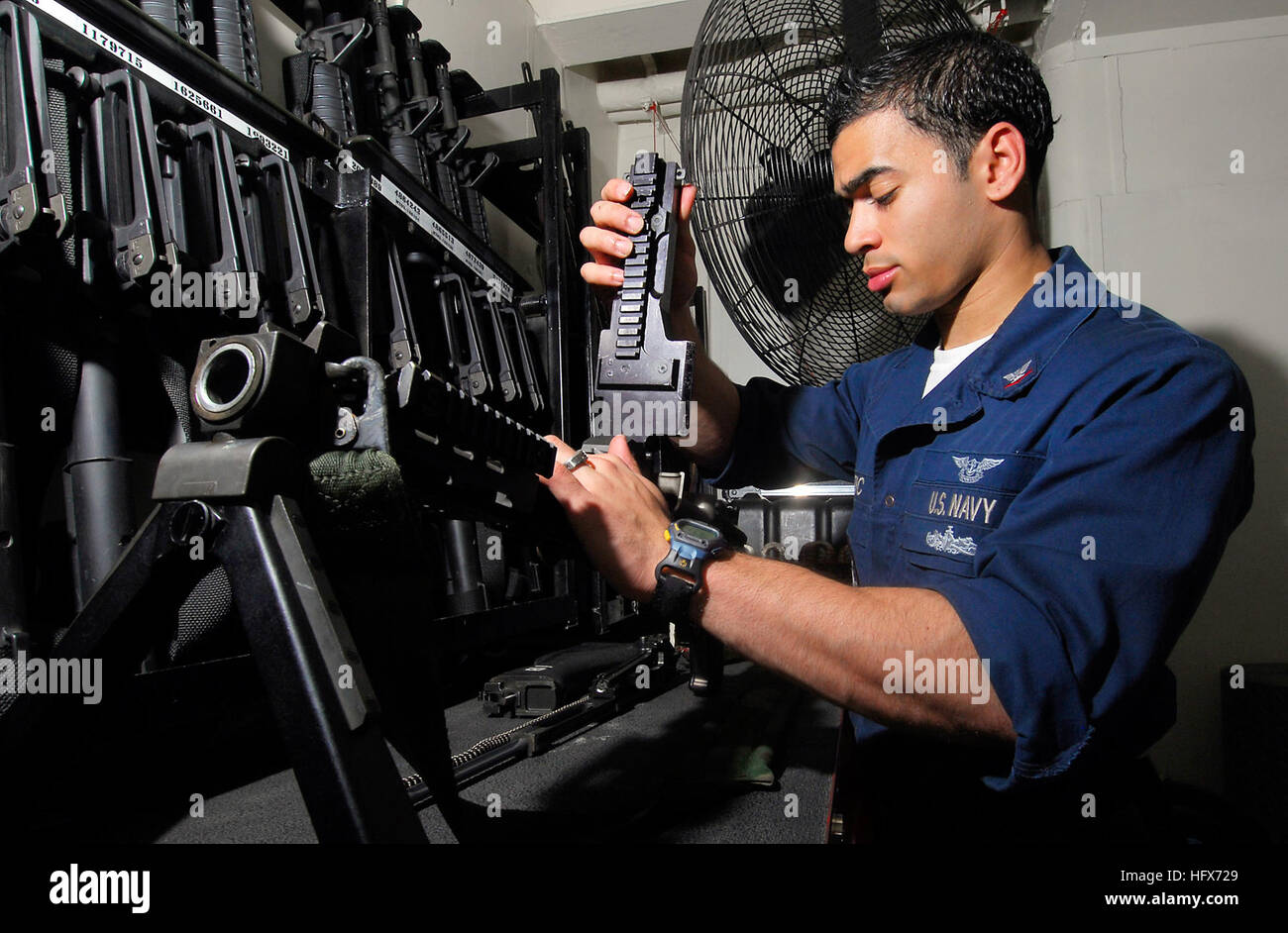 Aviation Ordnanceman cleans an M-240 machine gun in the armory aboard ...